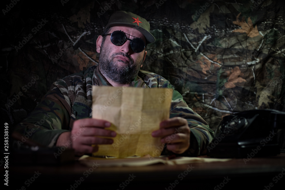 The evil dictator sitting on table. Angry communist general sitting at ...