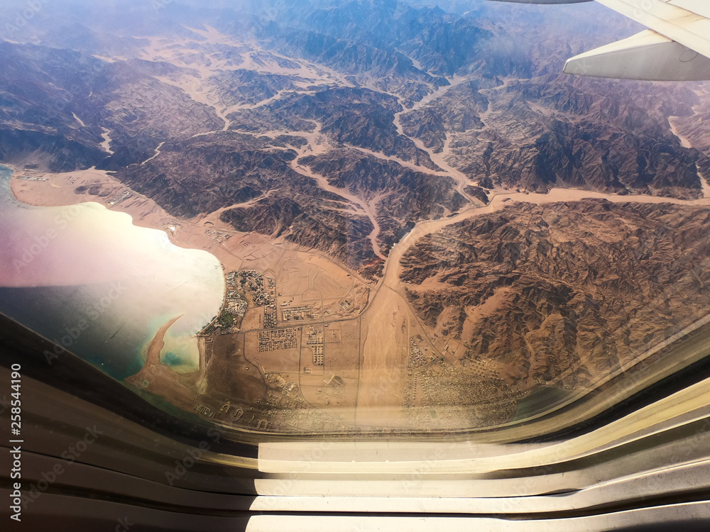 View from the window of the plane. In the window you can see the wing ...