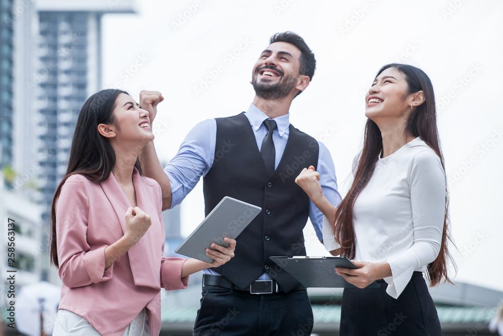 group of young man and women friends using a tablet and laughing ...