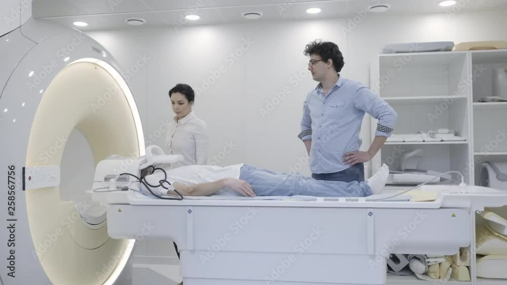 Clinic emergency MRI image head scan. Man lays in magnetic resonance ...