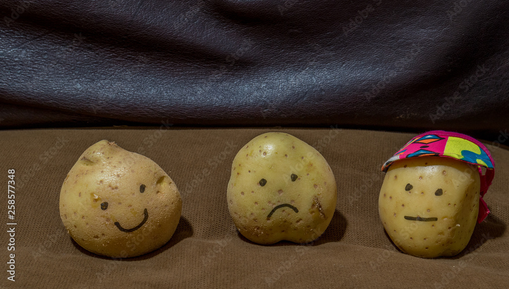 Three fresh potatoes on a brown couch lazy concept - image with copy ...