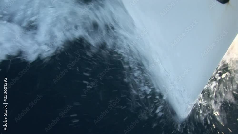 Close-up bow of white moving yacht breaks of sea waves of water surface ...