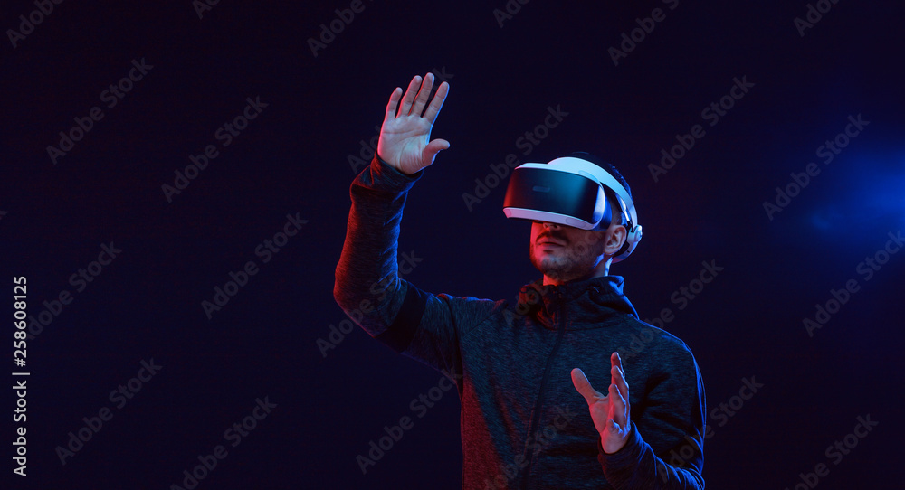 Model young man with beard in glasses of virtual reality on dark ...