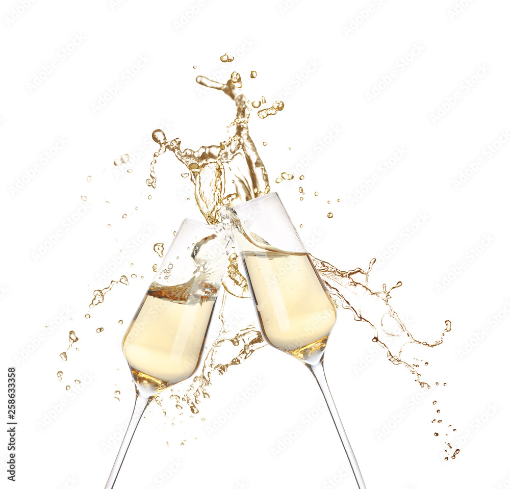 Glasses of champagne clinking together and splashing on white ...