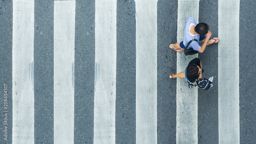 the top view of couple people walk across the pedestrian crosswalk in ...