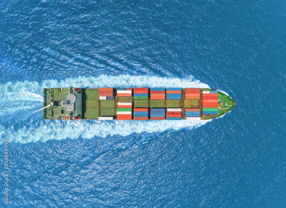 Aerial top view container ship full speed with wonderful wave pattern ...