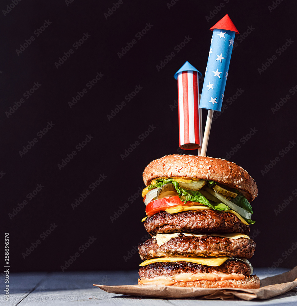 a big burger with three juicy beef patties bonded with American flag ...