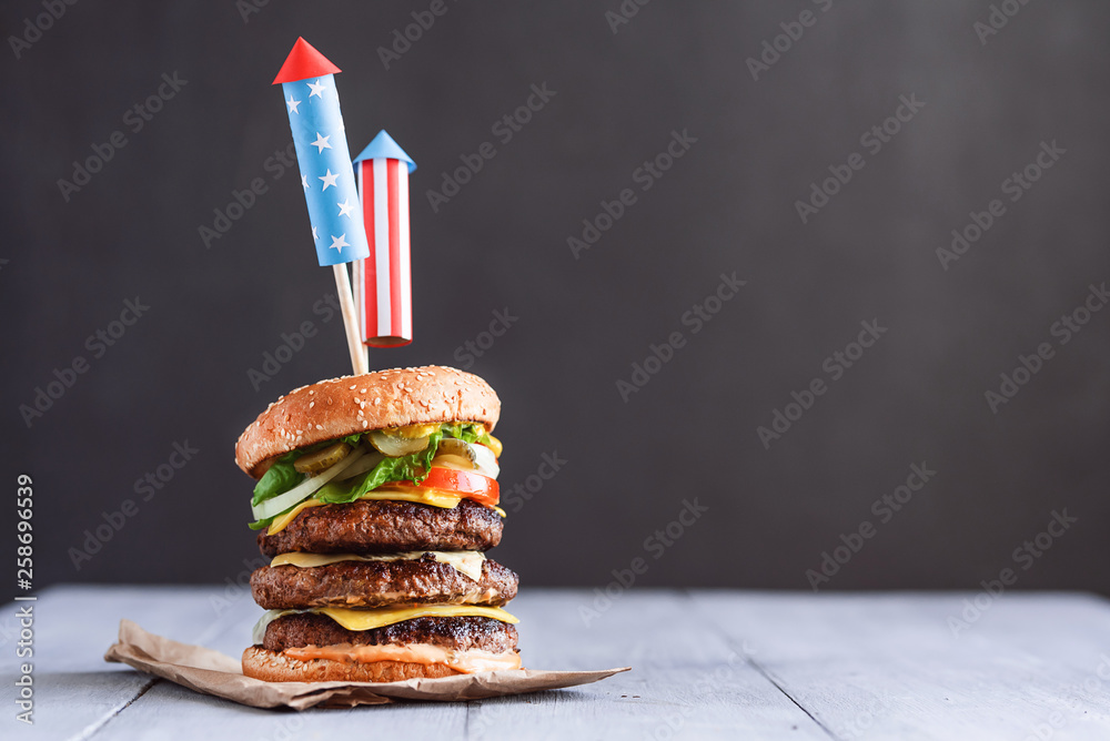 a big burger with three juicy beef patties bonded with American flag ...