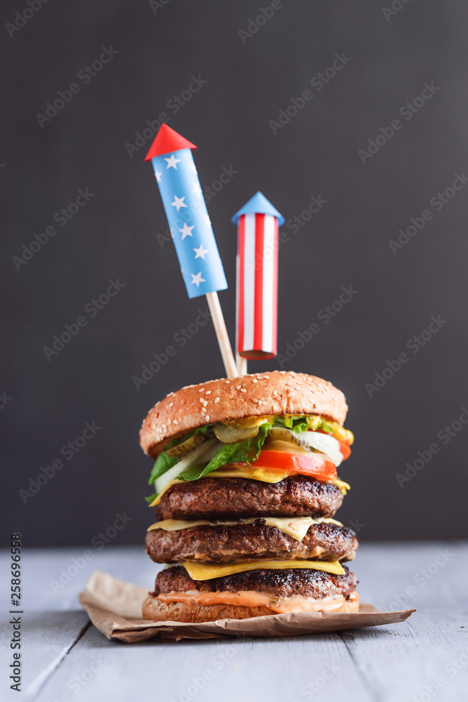 a big burger with three juicy beef patties bonded with American flag ...