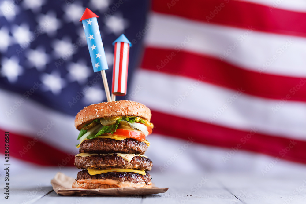 a big burger with three juicy beef patties bonded with American flag ...