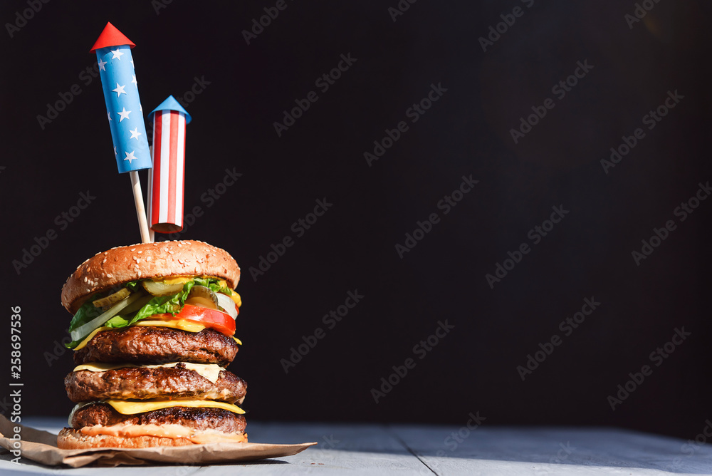 a big burger with three juicy beef patties bonded with American flag ...