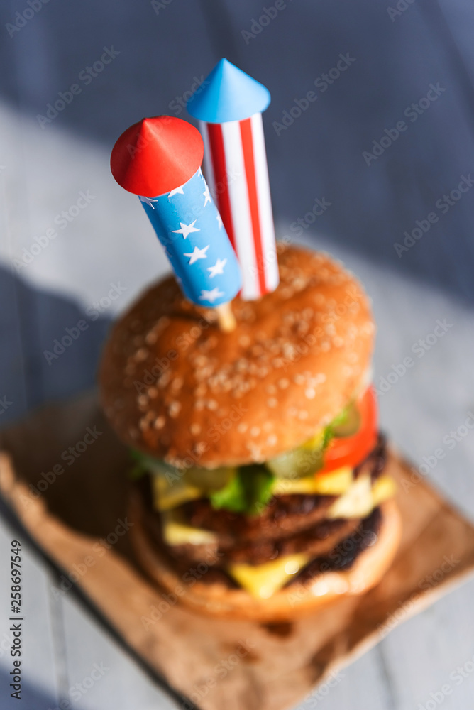 a big burger with three juicy beef patties bonded with American flag ...
