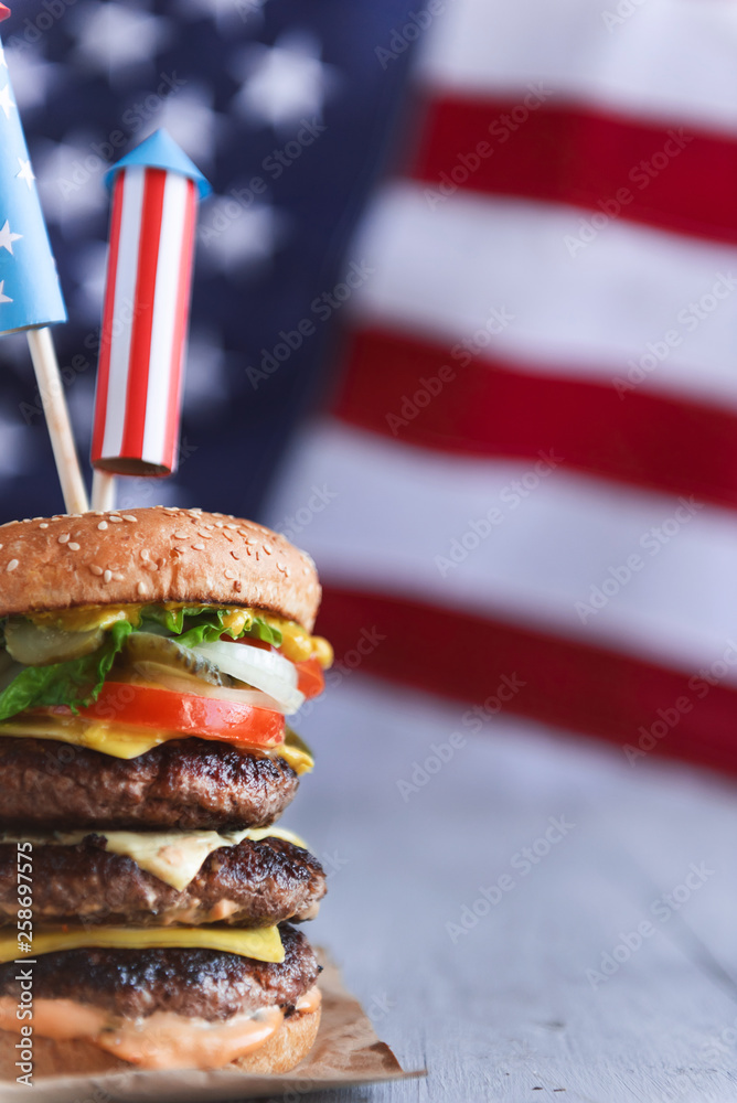 a big burger with three juicy beef patties bonded with American flag ...
