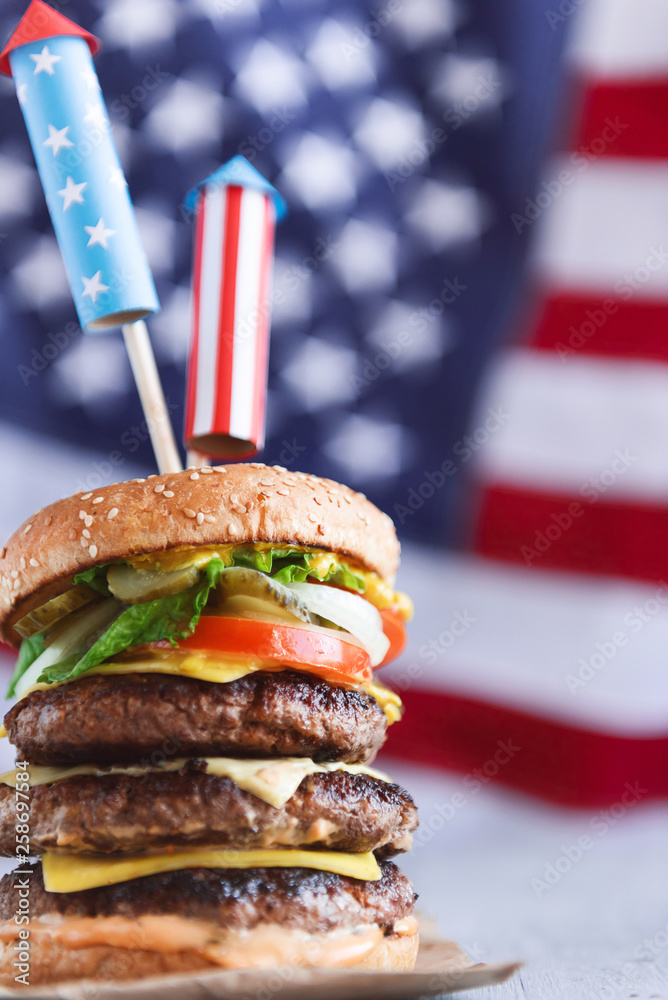 a big burger with three juicy beef patties bonded with American flag ...