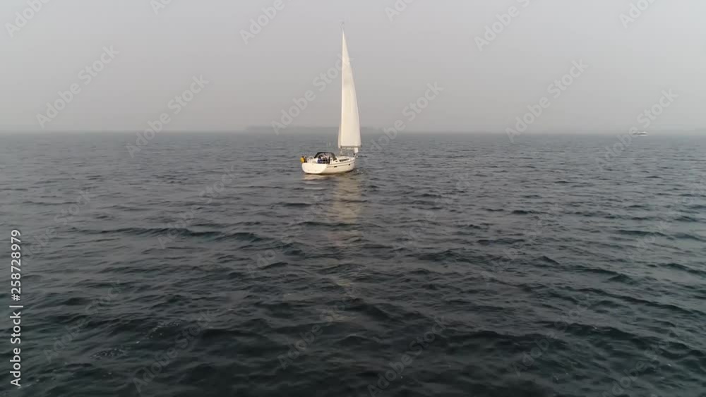 Aerial flyby past two sloops are sailing boats with single mast and ...