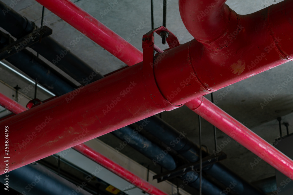 Fire sprinkler system with red pipes hanging from ceiling inside ...