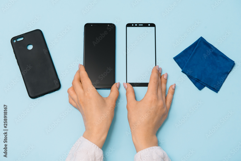 Smartphone with screen protect glass cover in hands. blue background ...
