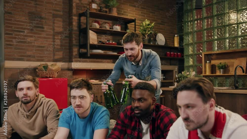 Four football fans are rooting for their favorite football team at home ...