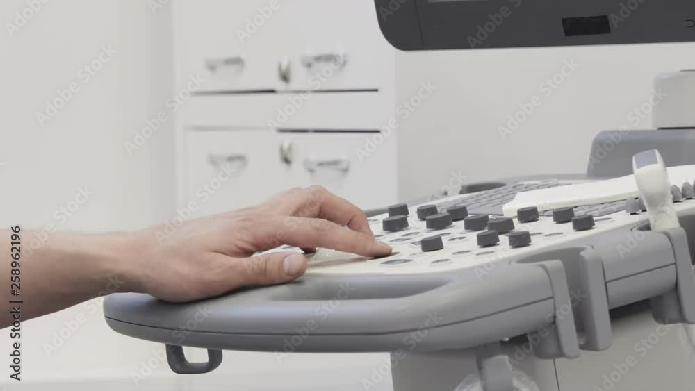 Doctor hand using ultrasonography equipment control the console and ...