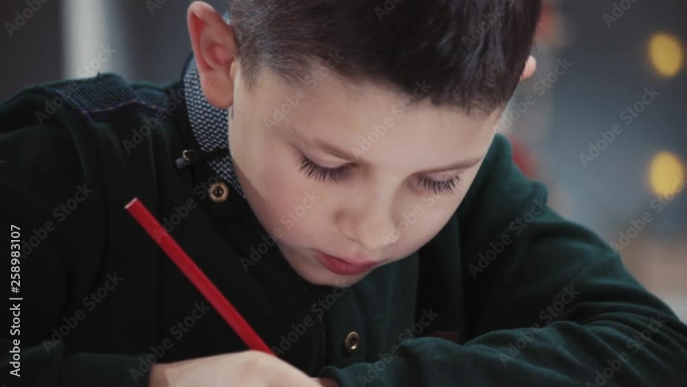 A little boy writing drawing with a pencil close up. Preteen handsome ...