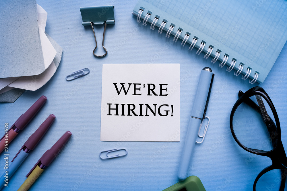 "WE ARE HIRING" CONCEPT. Office workplace top view, copy space.Flat lay ...