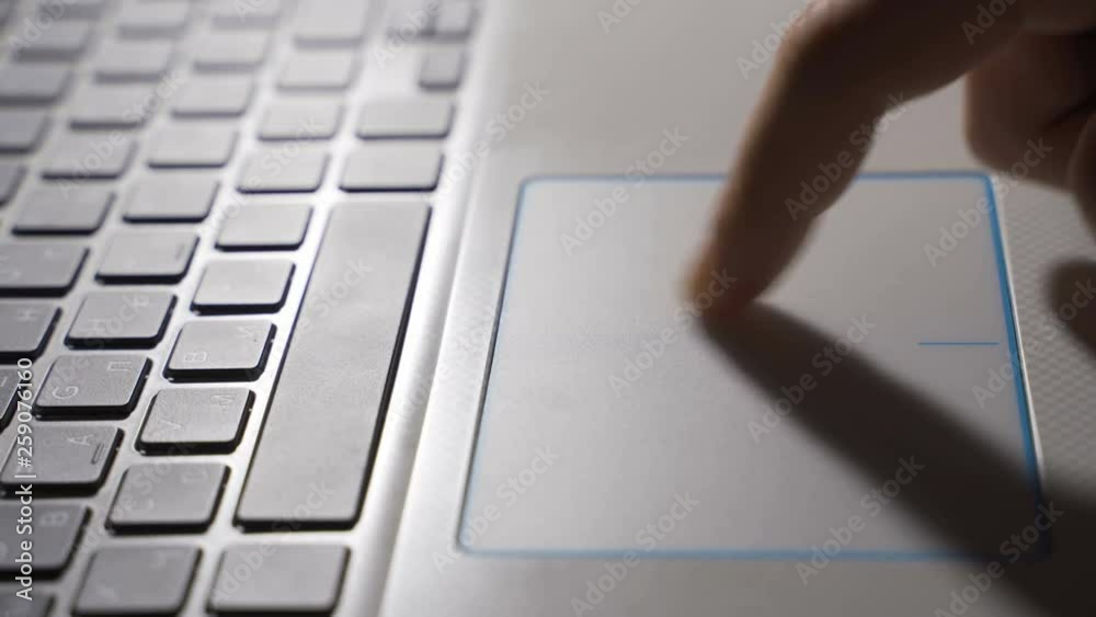 Close up touchpad and keyboard of laptop. Male fingers gestures at ...