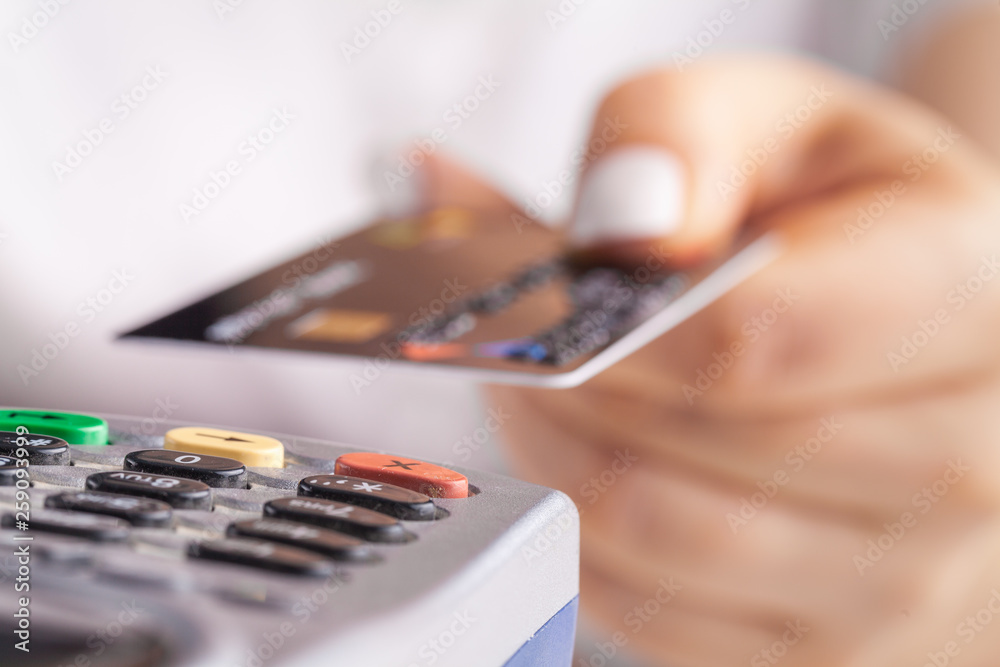 Paying with credit card. Female inserting chip card into payment ...