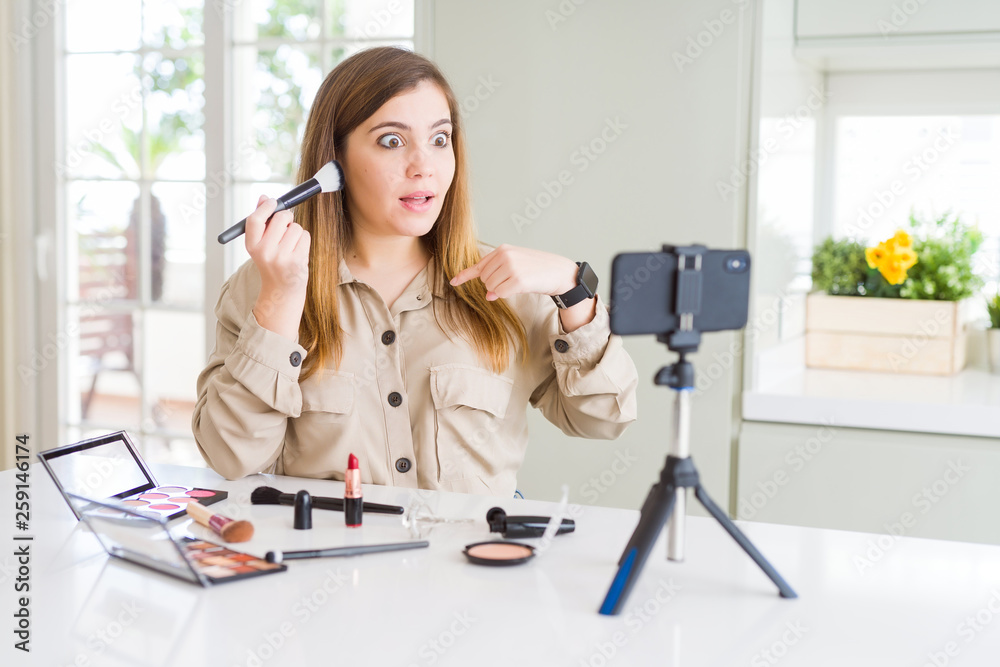 Beautiful young influencer woman recording make up video tutorial with ...