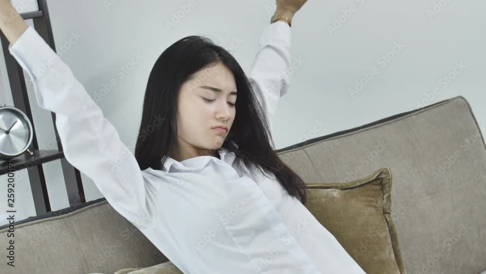 Vidéo Stock Relaxed girl sit on sofa, slowly and lazily stretch hands ...