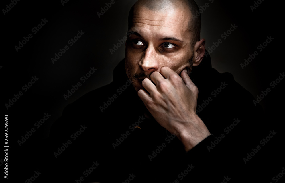 Dramatic dark portrait with strong contrast and film grain of young man ...