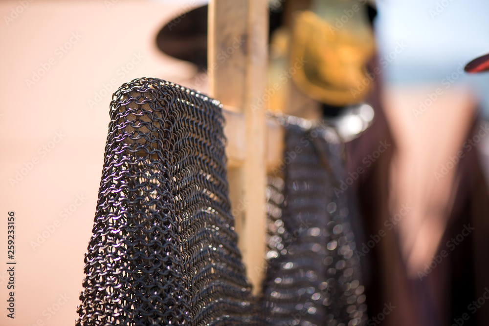 Medieval knight's iron chain armor on wooden cross hanger. Golden ...