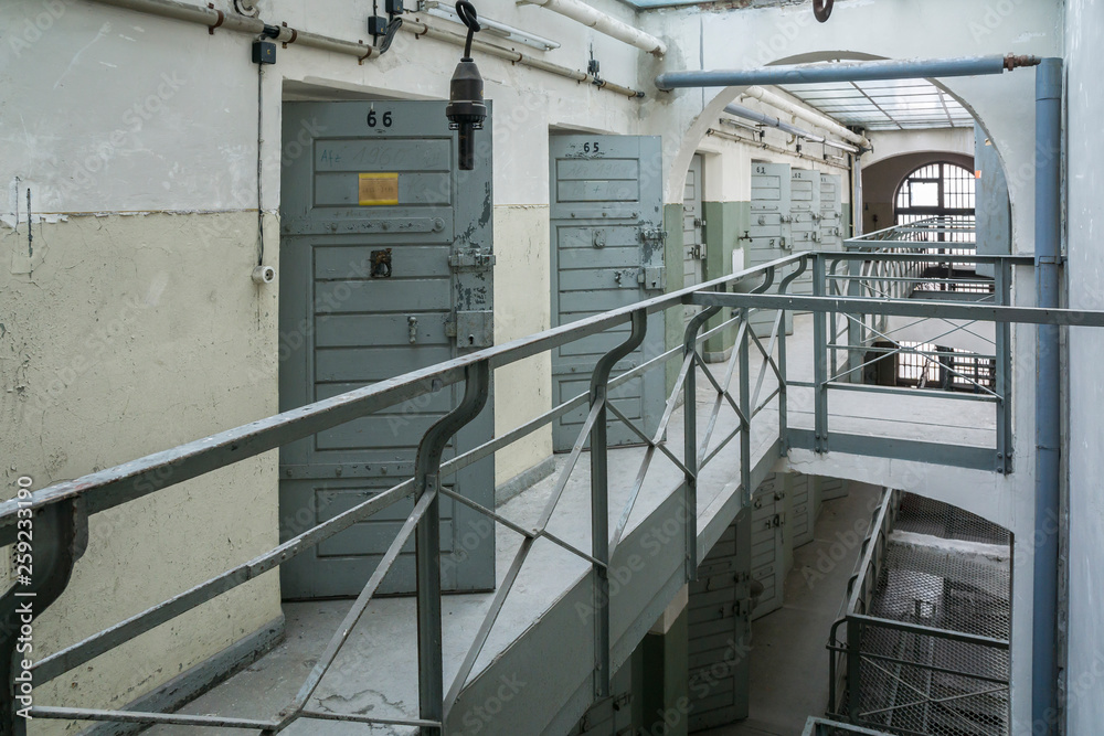 Indoor view of old deserted building, cells of prisoners with doors ...