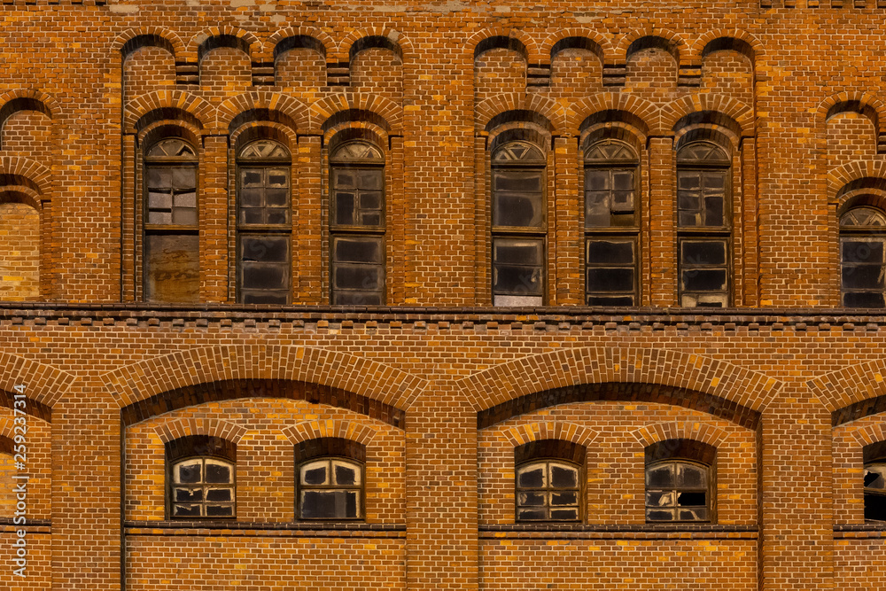 Facade of the old mill building at nighttime. Building of red brick ...