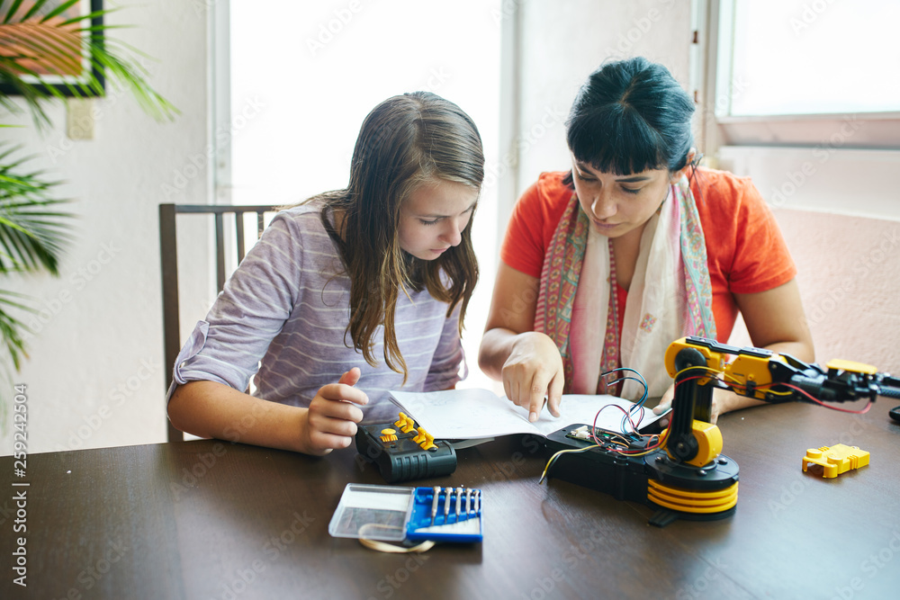 Adult with young student assembling a robotics kit Stock Photo | Adobe ...