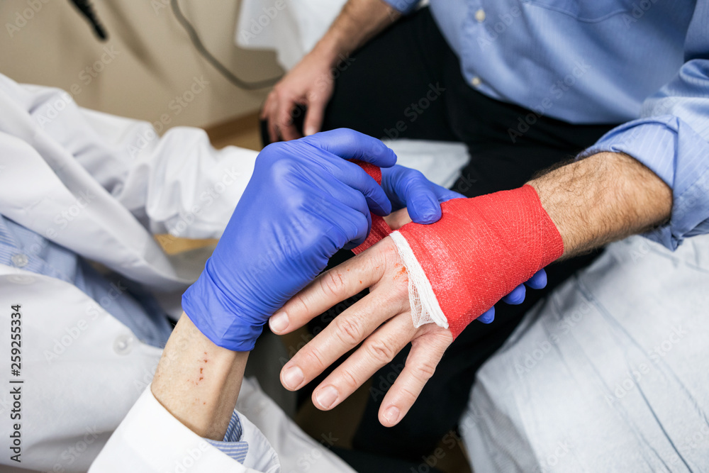 Clinic: Doctor Wraps Patient Hand With Gauze And Bandage Stock Photo ...