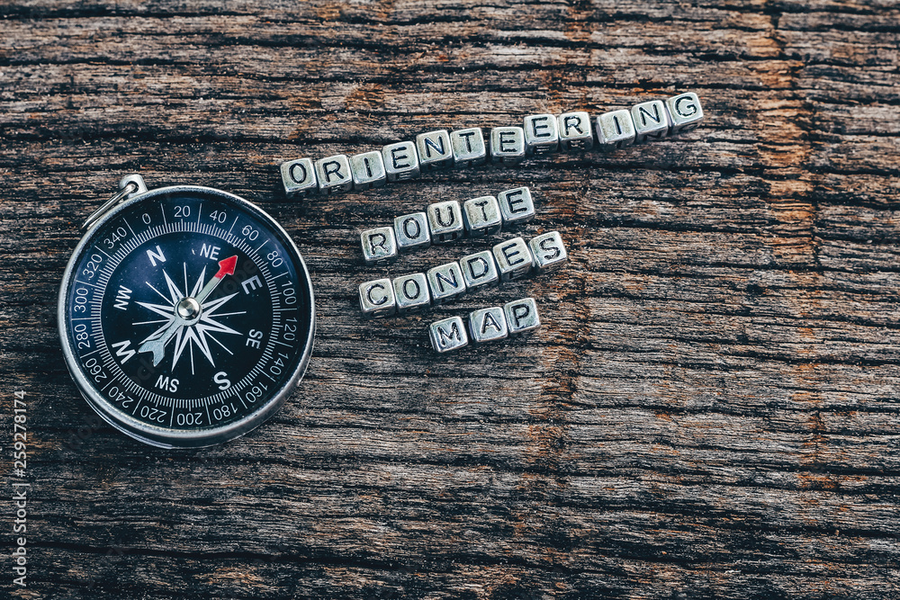 Compass on wood deck with blocks of letters making the word ...