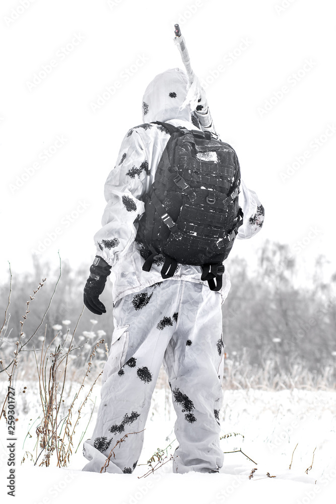 Man soldier in the winter on a hunt with a sniper rifle in white winter ...