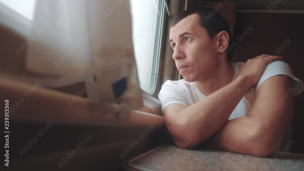 Vidéo Stock man sad bored riding a train railway looks out the window ...