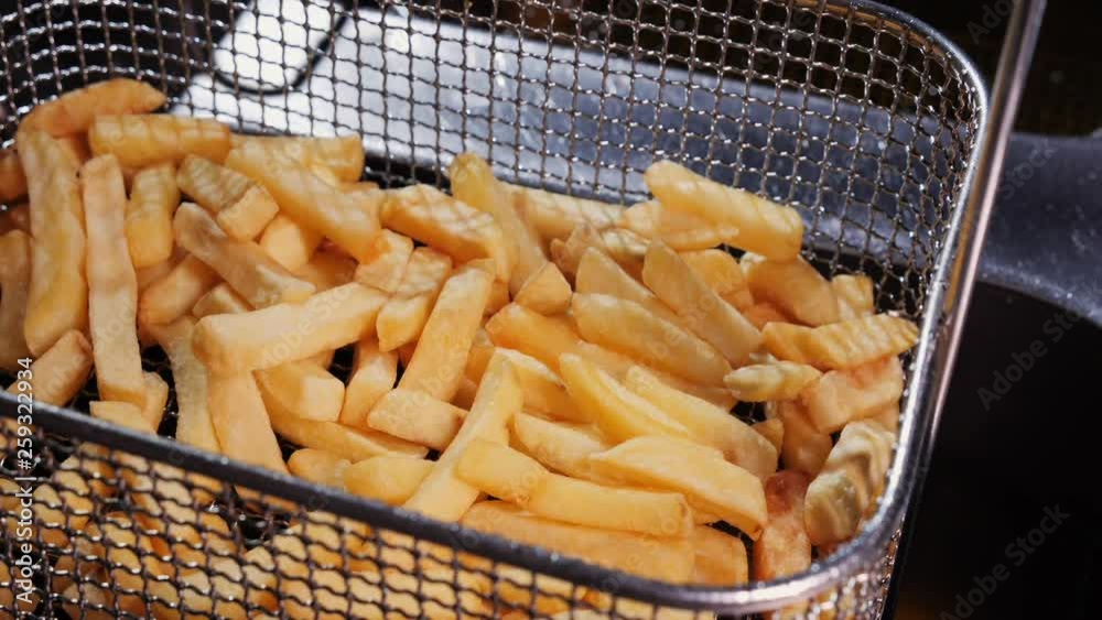 French fries ready to be served in a wire basket - close up, camera ...