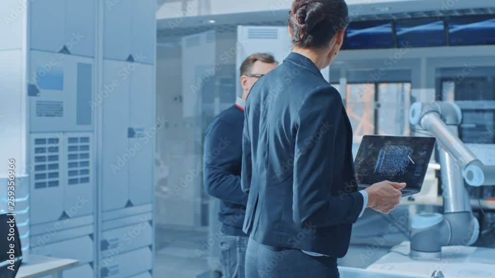 Following Shot of Stylish Female Chief Engineer Holding Laptop Computer ...