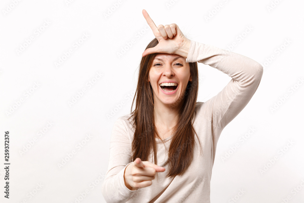 Laughing young woman in light clothes showing looser gesture pointing ...