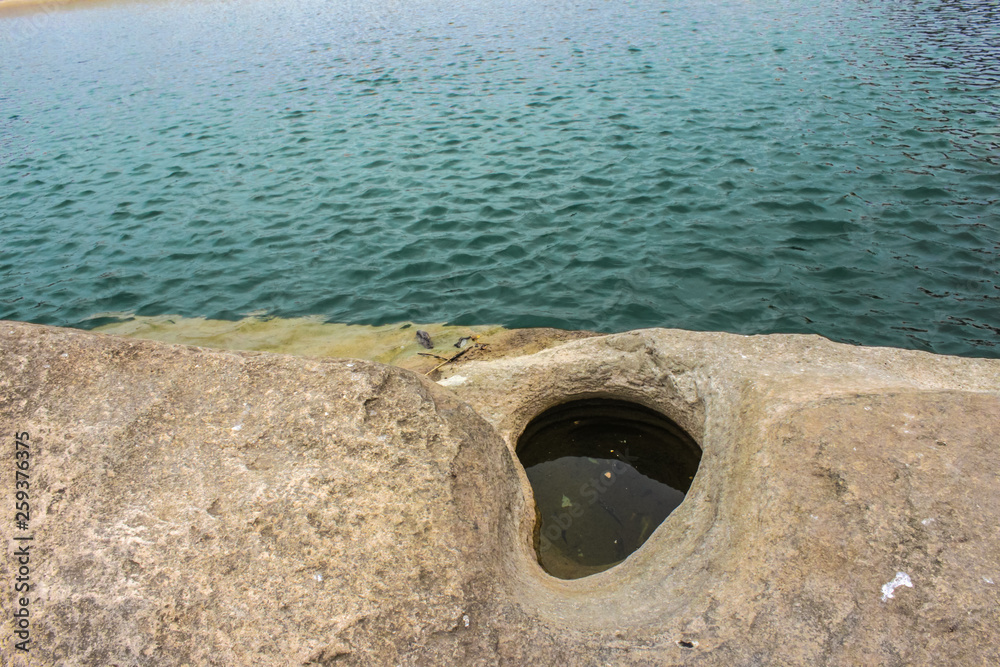 Sinkhole in rock-one hole filled with water in rock by Pedernales River ...