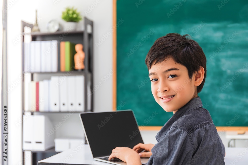 Asian happy school boy using laptop on black board background with ...