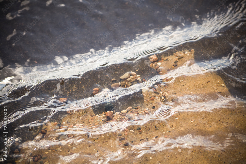 Background water. Asphalt and sand. Stream of water over the asphalt ...