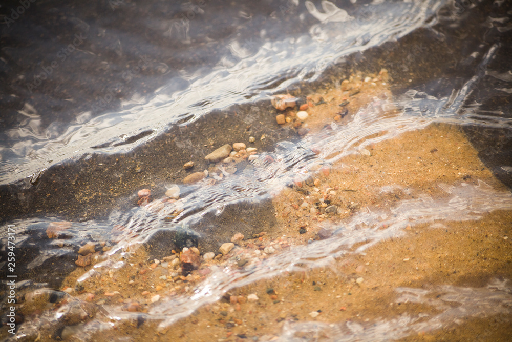 Background water. Asphalt and sand. Stream of water over the asphalt ...