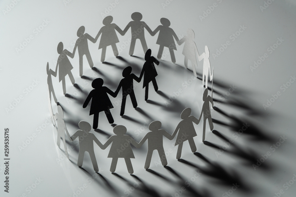 Three human paper figures surrounded by circle of paper people holding ...
