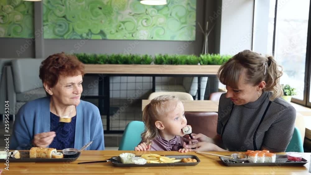 The child eats with pleasure from the hands of mother and grandmother ...