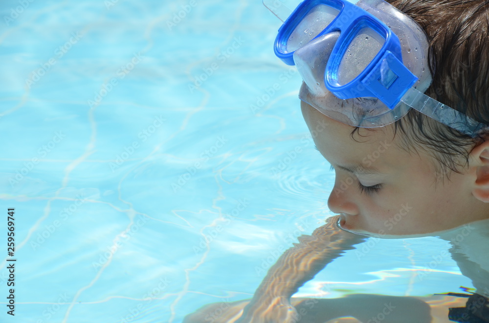 Teenager boy wearing mask swimming in the pool. Happy holiday concept ...