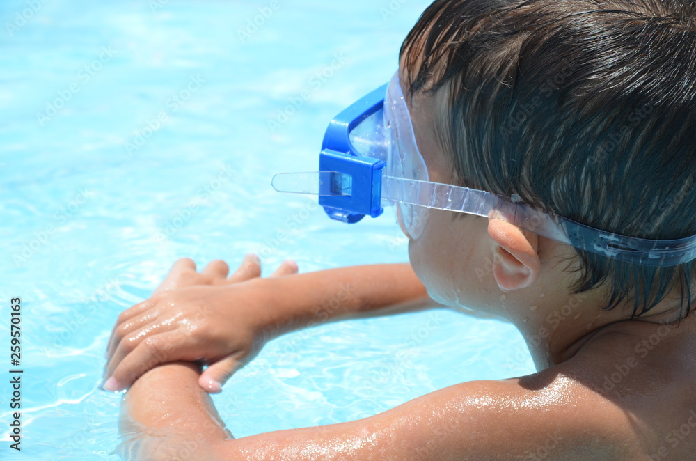 Teenager boy wearing mask swimming in the pool. Happy holiday concept ...