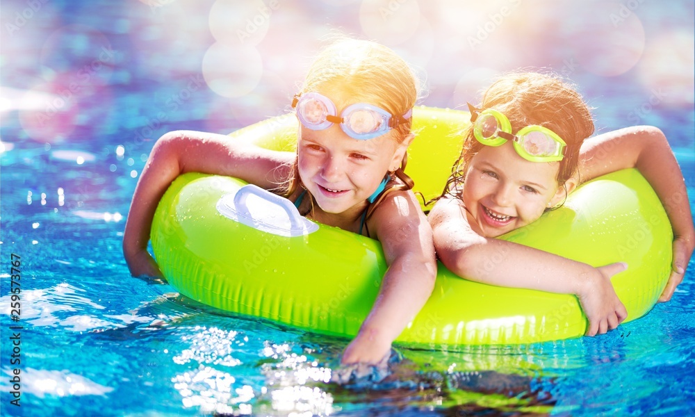 Children playing in pool. Two little girls having fun in the pool ...